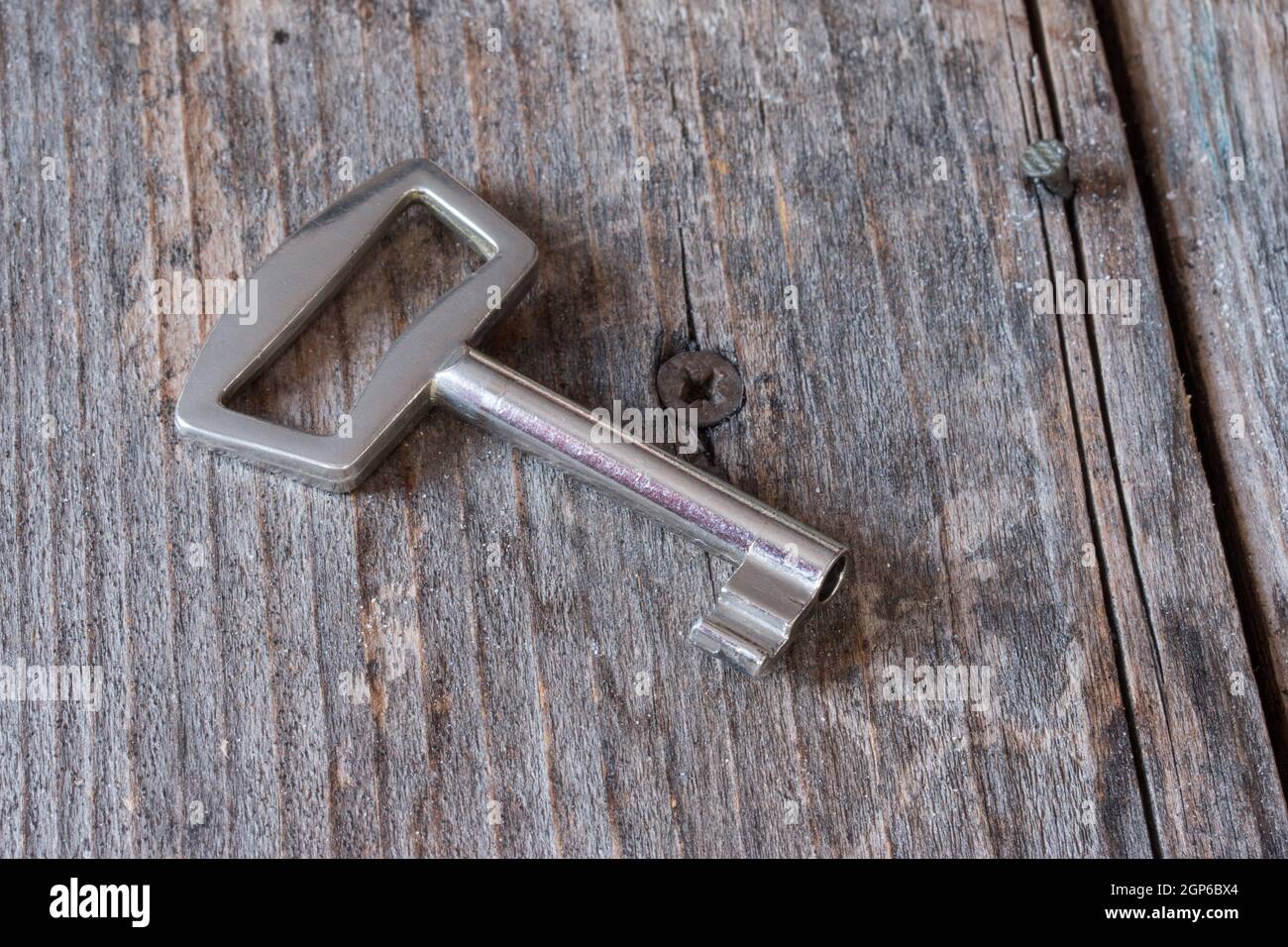 Old key is lying on a rustic wooden desk Stock Photo - Alamy