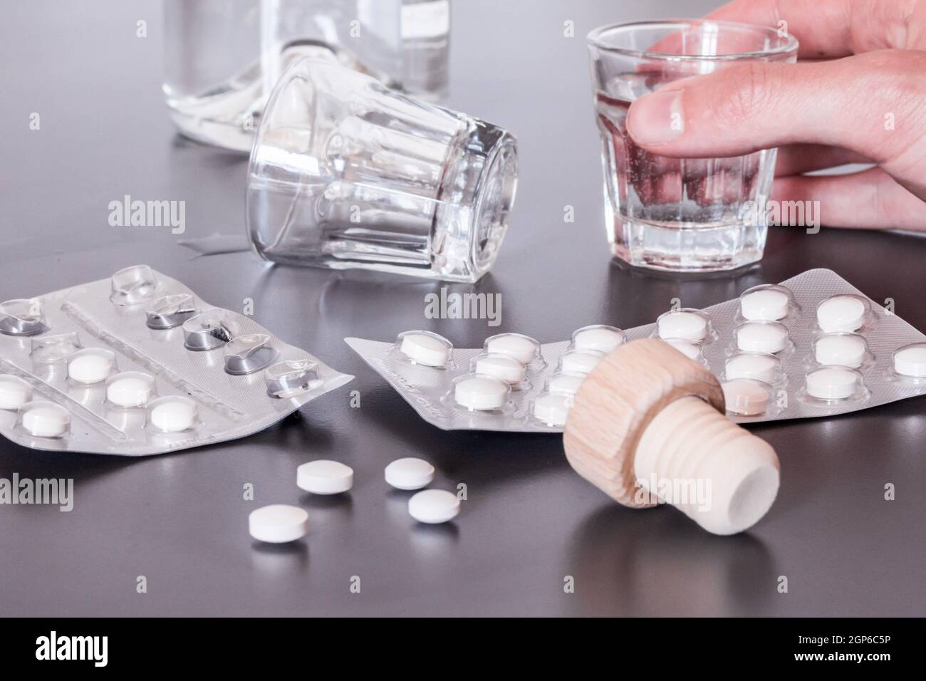 Pills and alcohol on a grey table. Concept for drug abuse Stock Photo ...