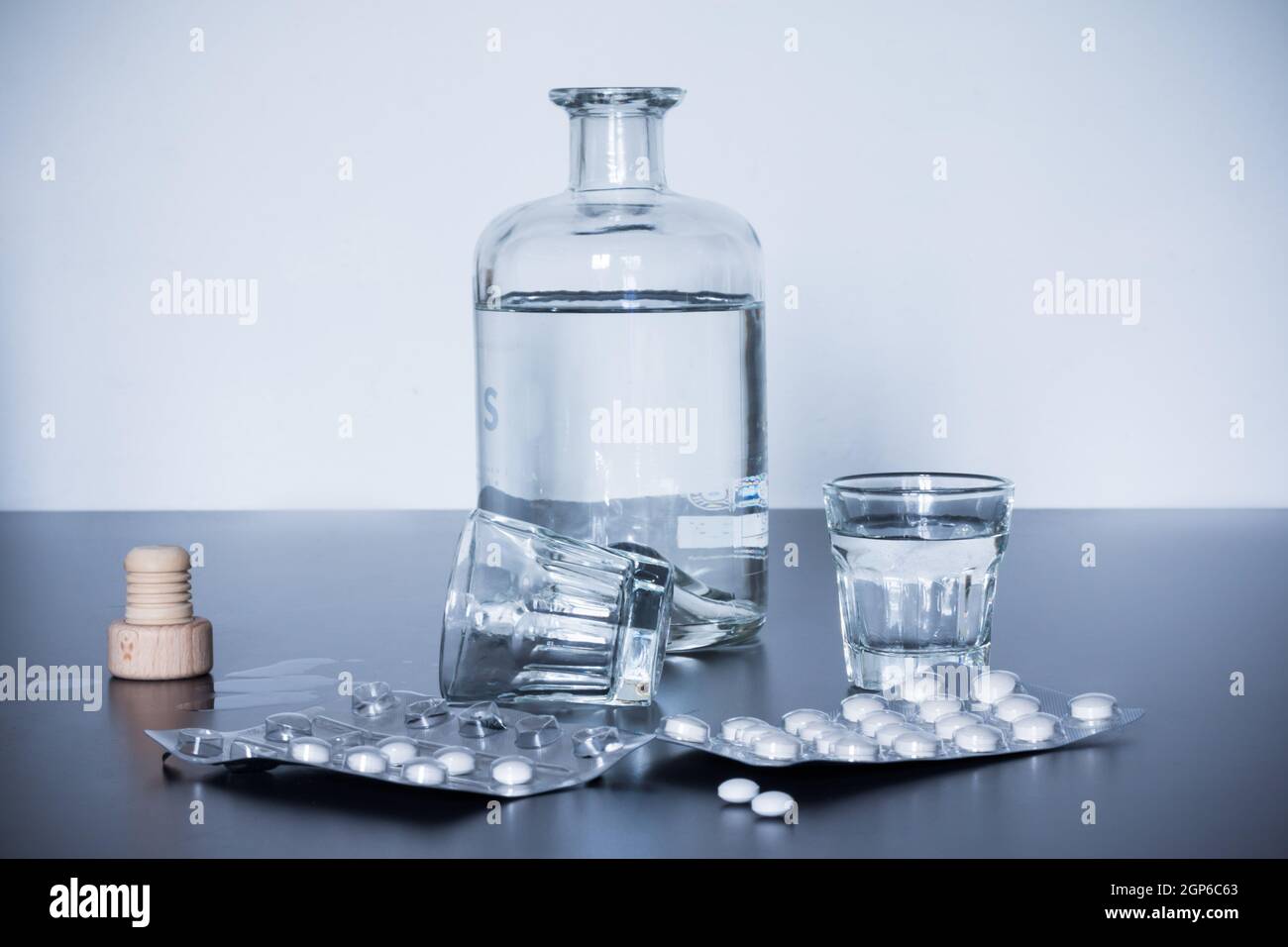Pills and alcohol on a grey table. Concept for drug abuse Stock Photo ...