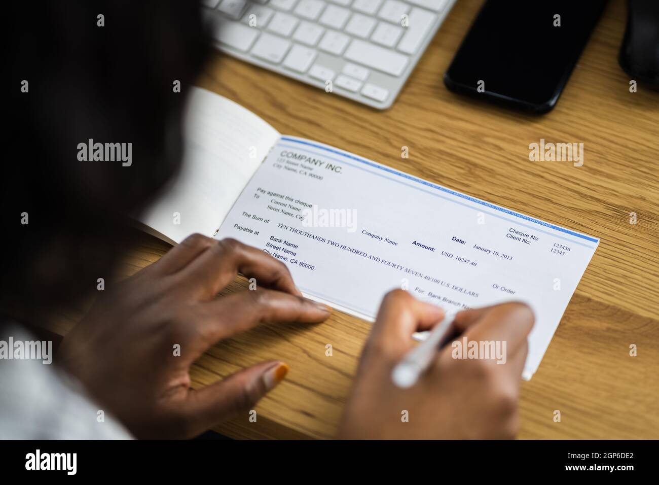 African Woman Signing Bank Check Or Paycheck Stock Photo - Alamy