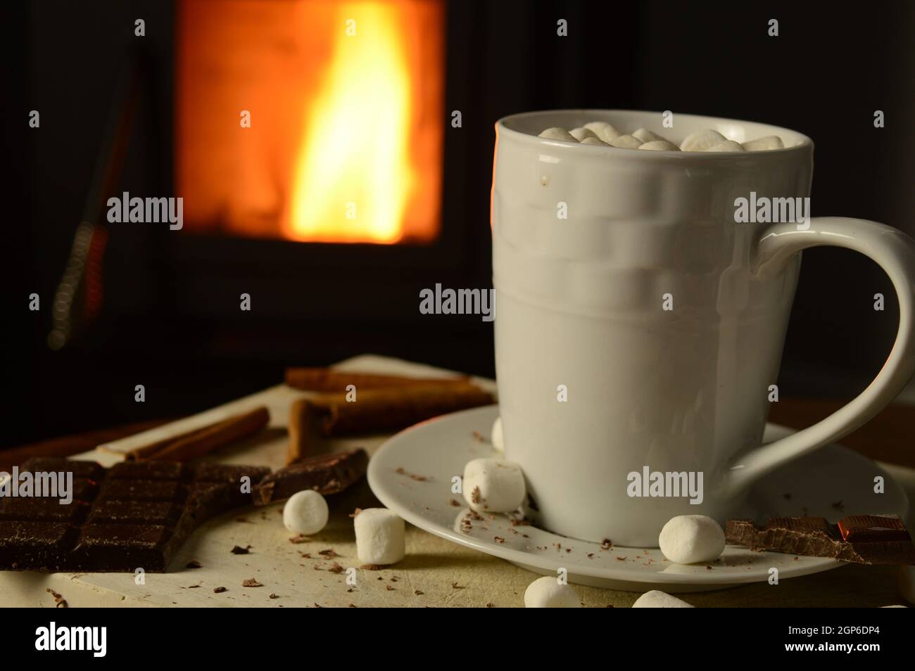 A cup of hot chocolate resting in front of a wood stove fire Stock ...
