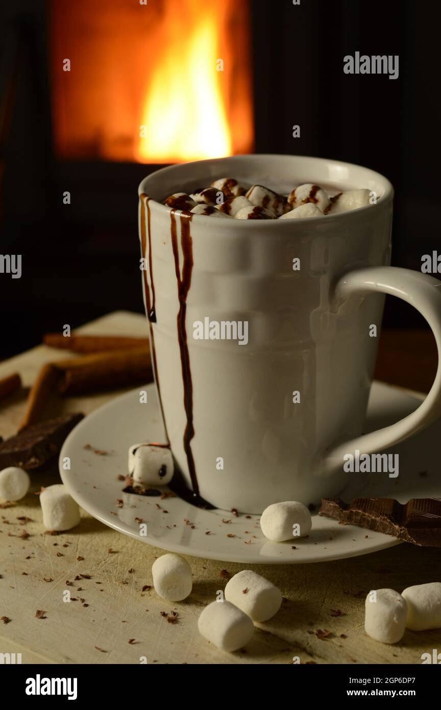 A cup of hot chocolate resting in front of a wood stove fire Stock ...