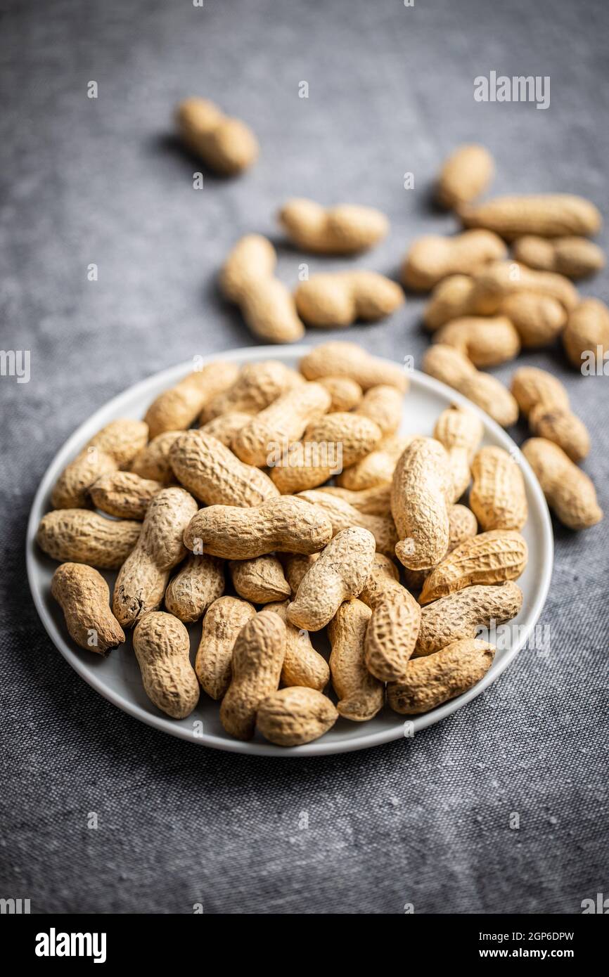 Roasted peanuts. Tasty groundnuts on plate on tablecloth Stock Photo ...