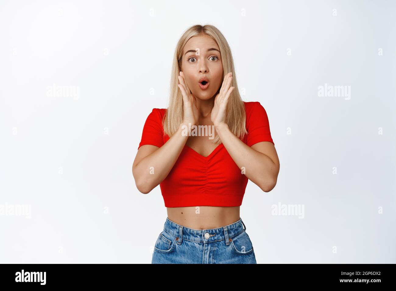 Surprised blond woman gasping amazed, looking impressed at camera, say ...