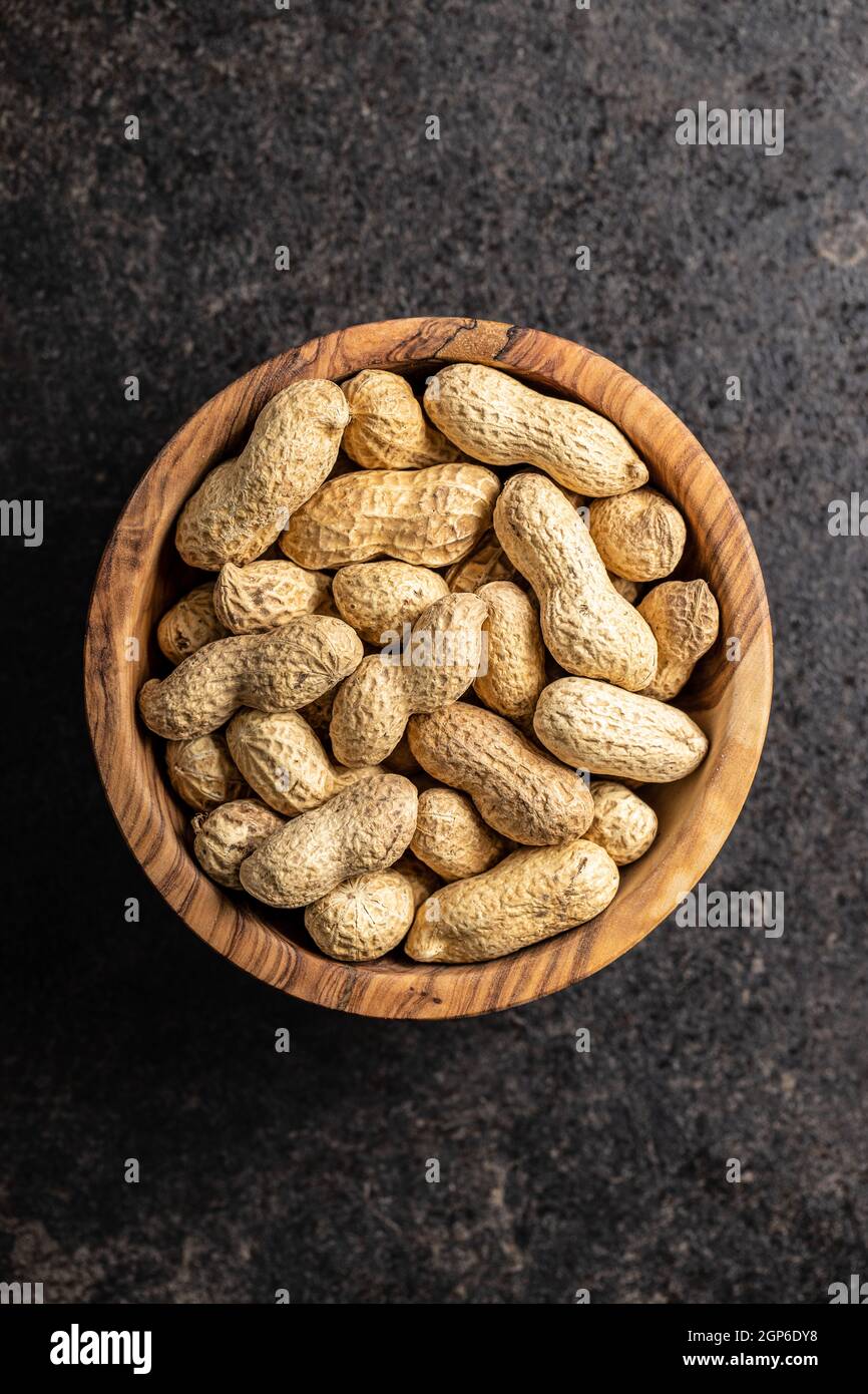 Dried peanuts. Tasty groundnuts in bowl on black table. Top view Stock ...