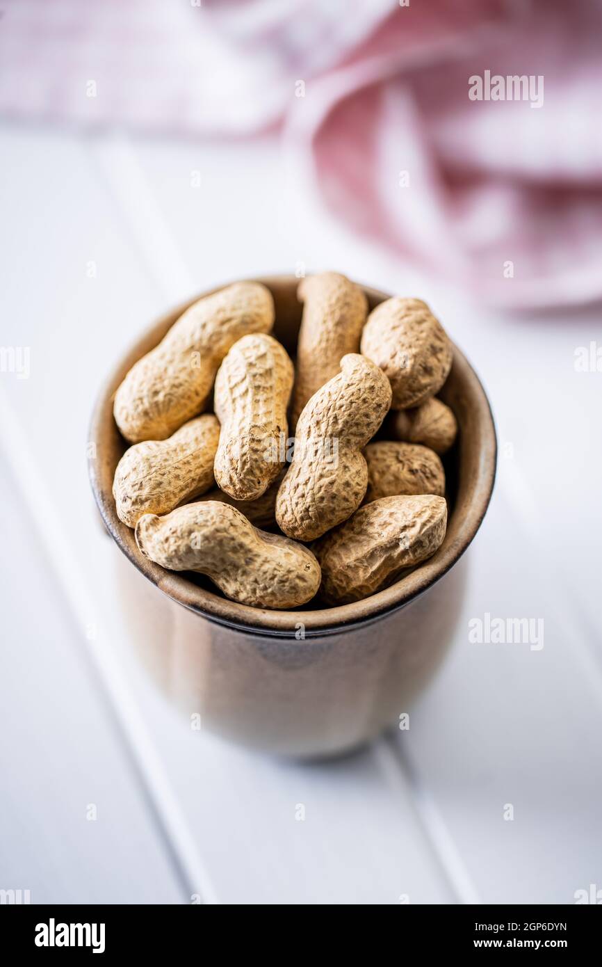 Roasted peanuts. Tasty groundnuts in cup on white table Stock Photo - Alamy