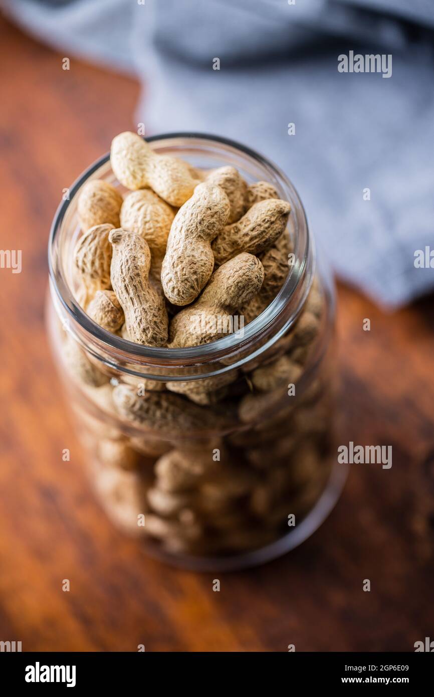 Roasted peanuts. Tasty groundnuts in jar on wooden table Stock Photo ...