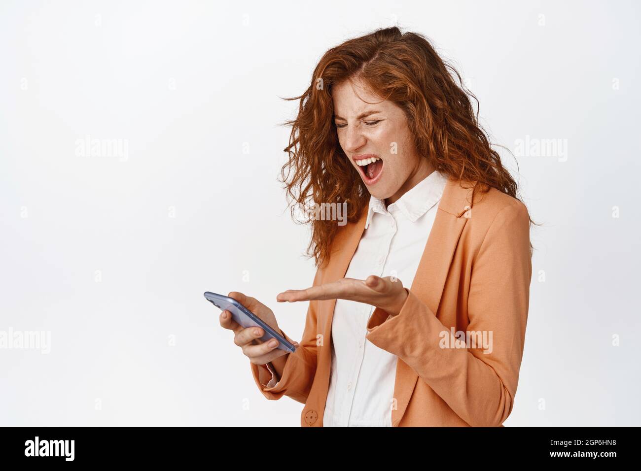 Angry and frustrated businesswoman shouting at her mobile phone ...