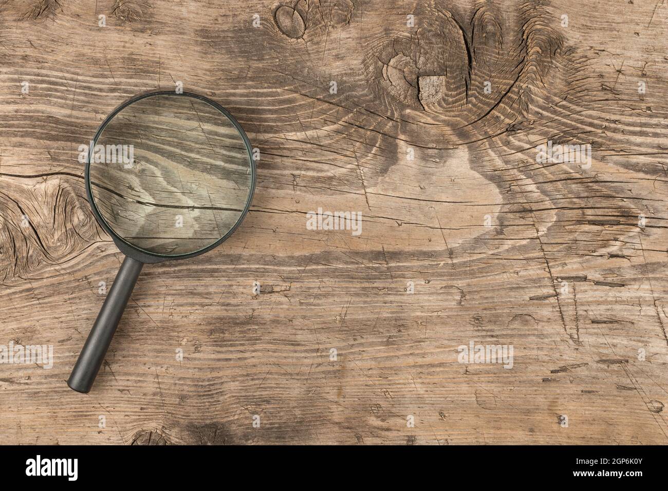 Magnifying glass lying on a wooden surface, top view Stock Photo - Alamy