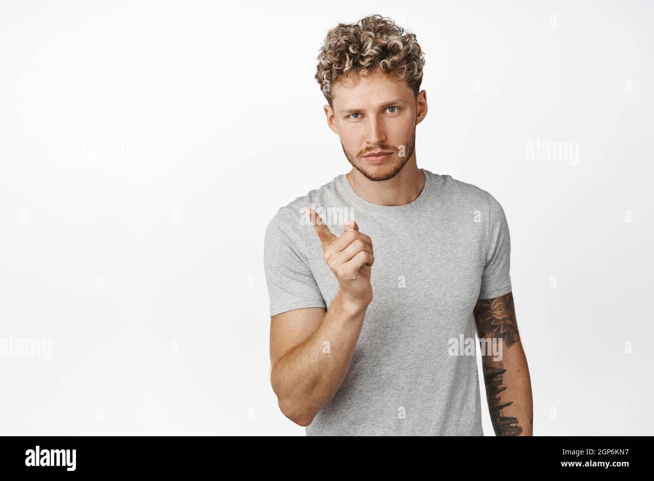 Image of stylish blond man shaking finger in disapproval, scolding smth ...