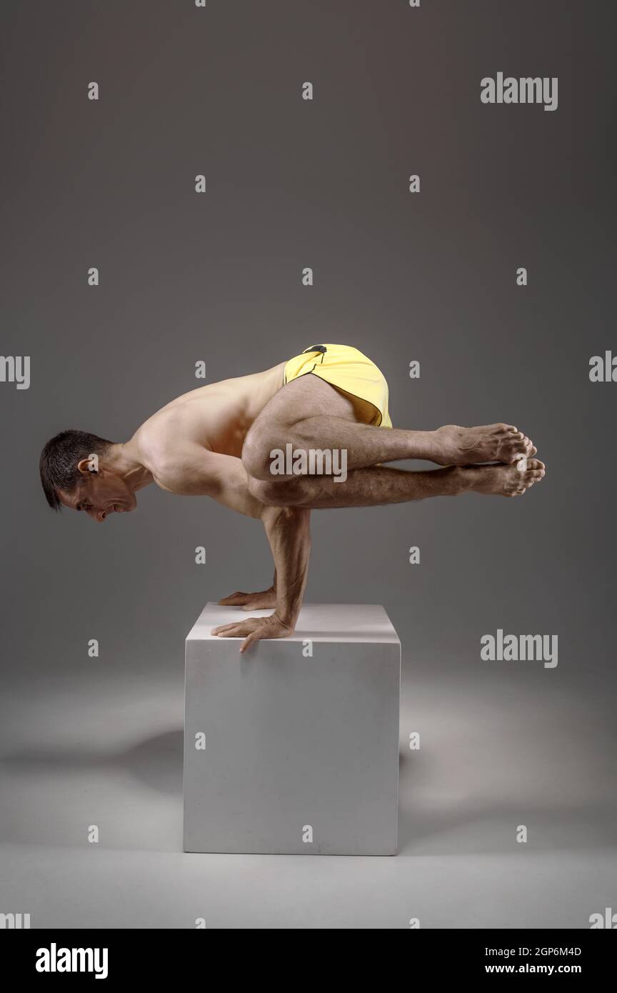 Yoga keeps balanc on hands in difficult pose on the pedestal ...