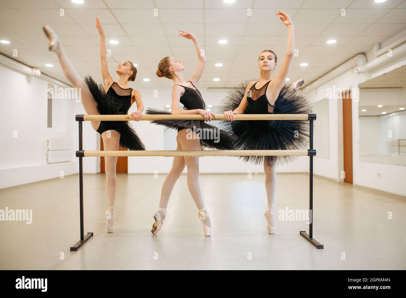 Elegant teen ballerinas poses at the barre in class. Ballet school ...