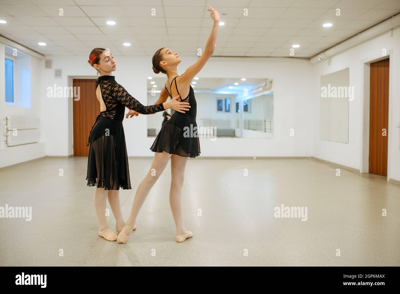 Master rehearsing with young ballerina in class. Ballet school, female dancers on choreography ...