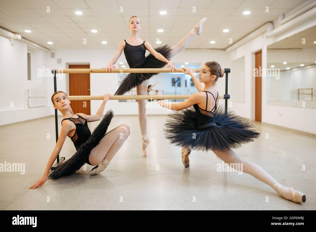 Elegant teen ballerinas poses at the barre in class. Ballet school, female dancers on ...