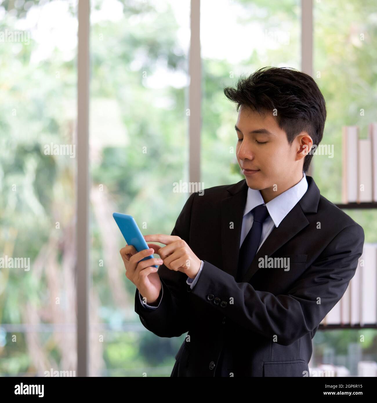 Young asian businessman in black suit close both eye before pushing ...
