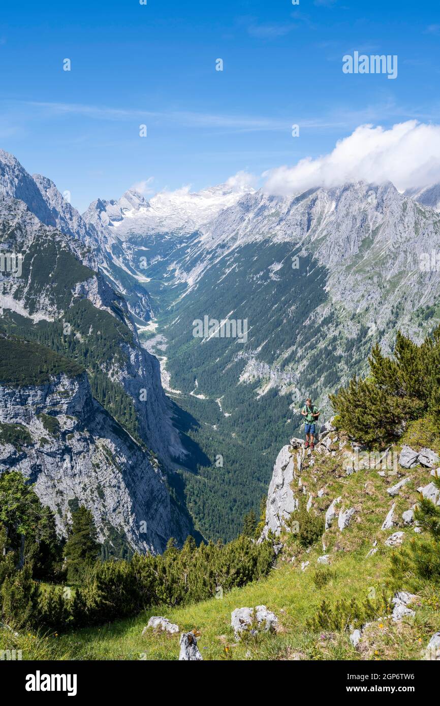 Hiker looking into the camera, view into the Reintal valley, in the ...