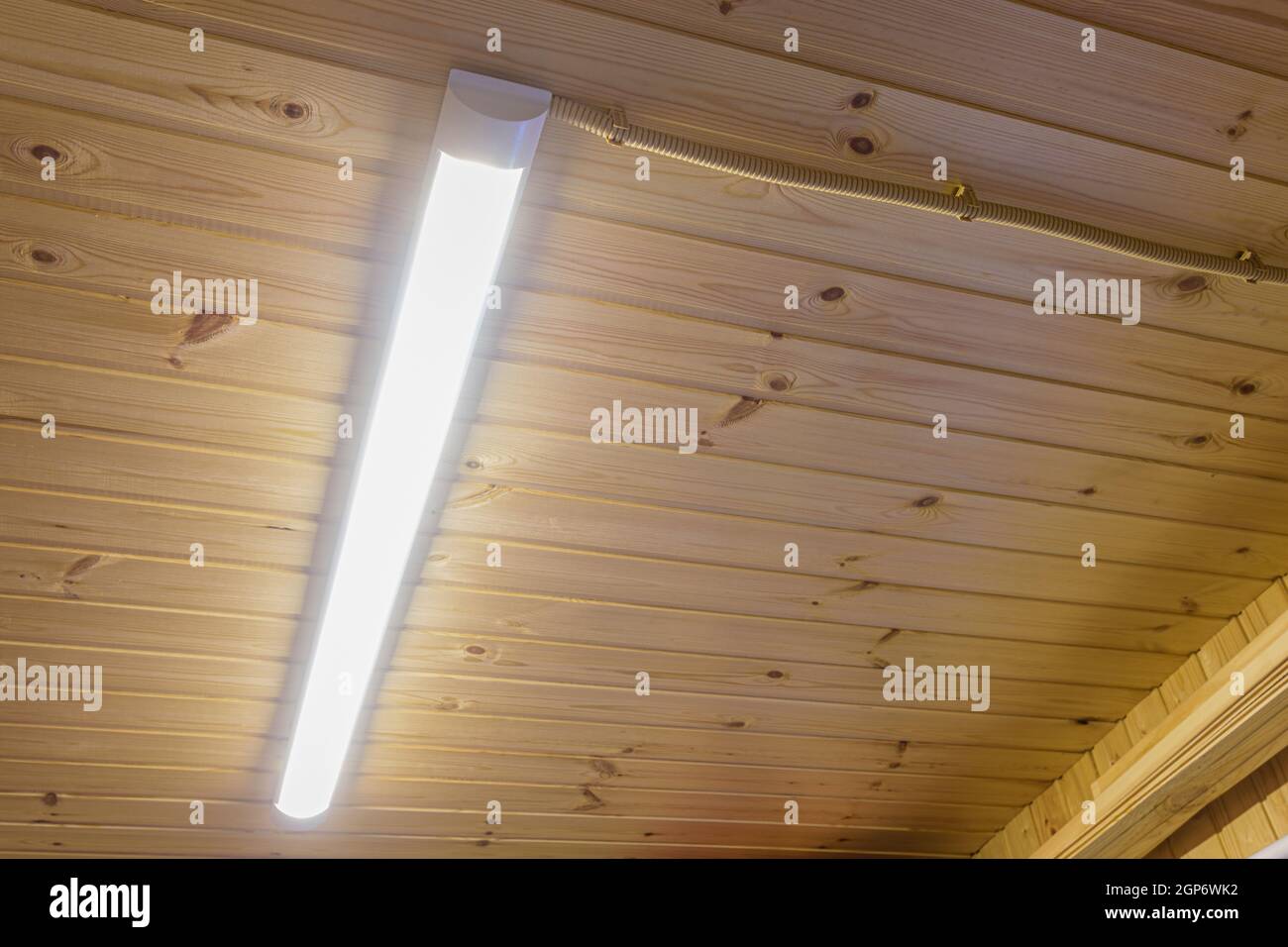 Included daylight lamp on wood paneling ceiling Stock Photo - Alamy