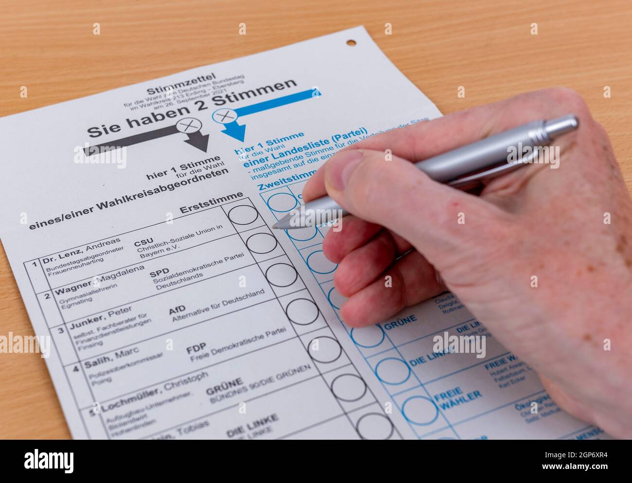Hand with biros over ballot paper for the election of members of the ...