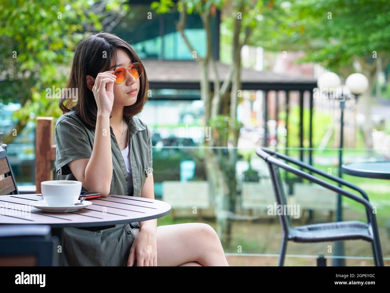 Pretty woman sitting in a cafe terrace with coffee cup Stock Photo - Alamy