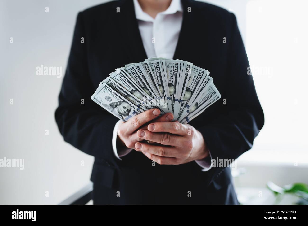 One hundred dollar bills money fun, in hand of man in suit and white ...