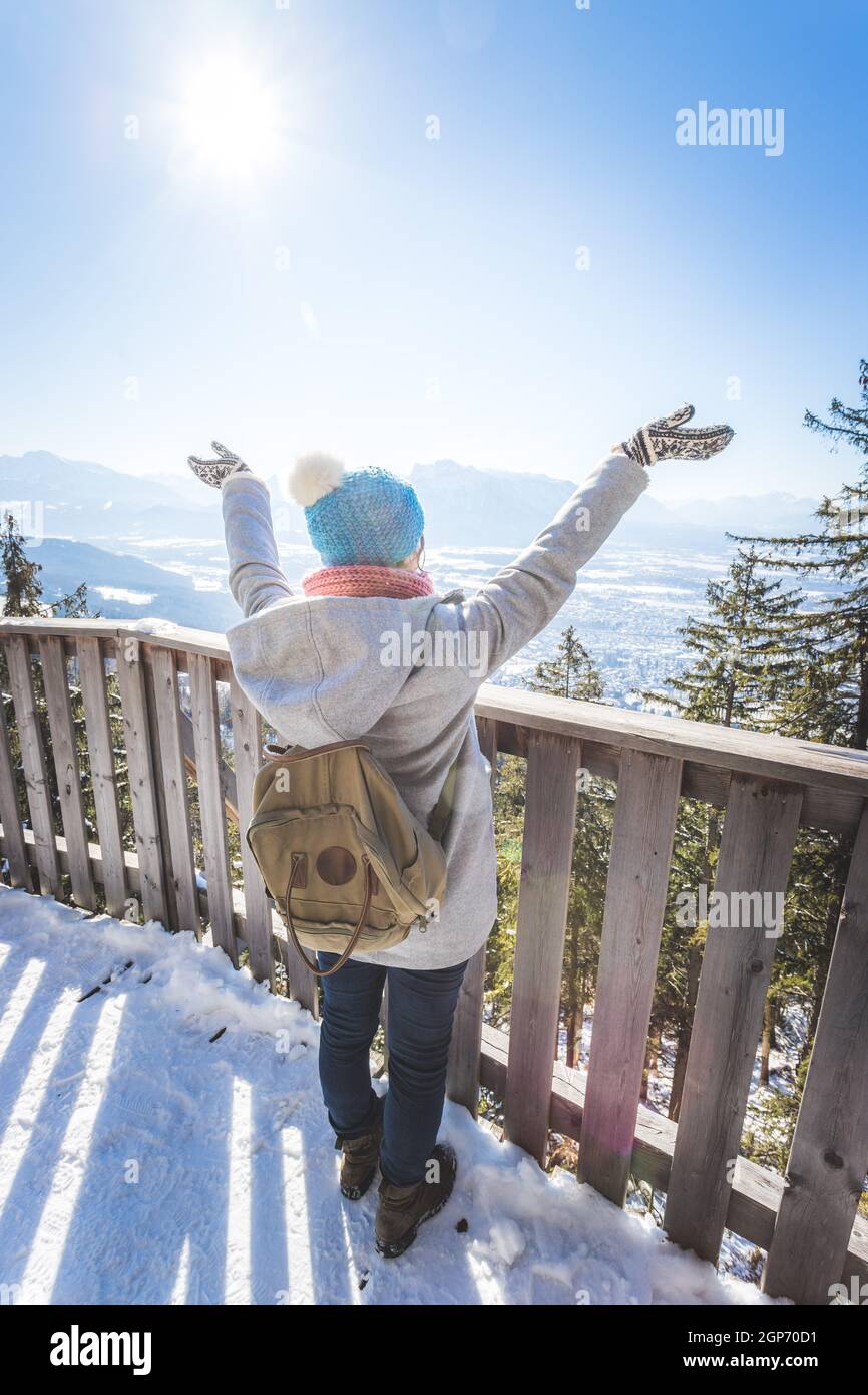 Back of young woman who is raising her hands on the mountain, outlook ...