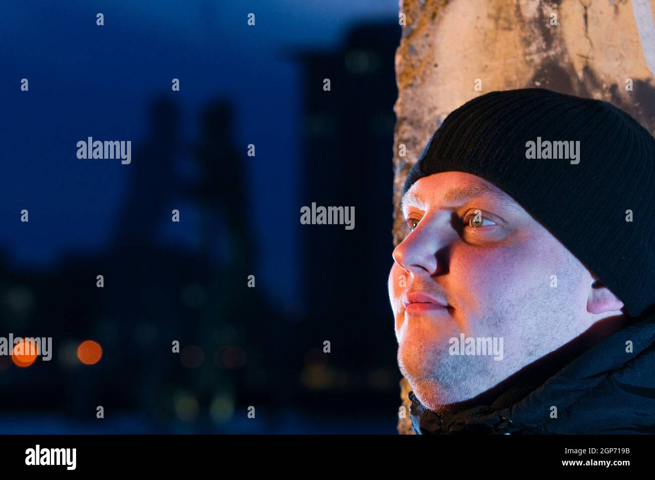 Lateral head portrait of a young man with a black cloth cap leaning ...