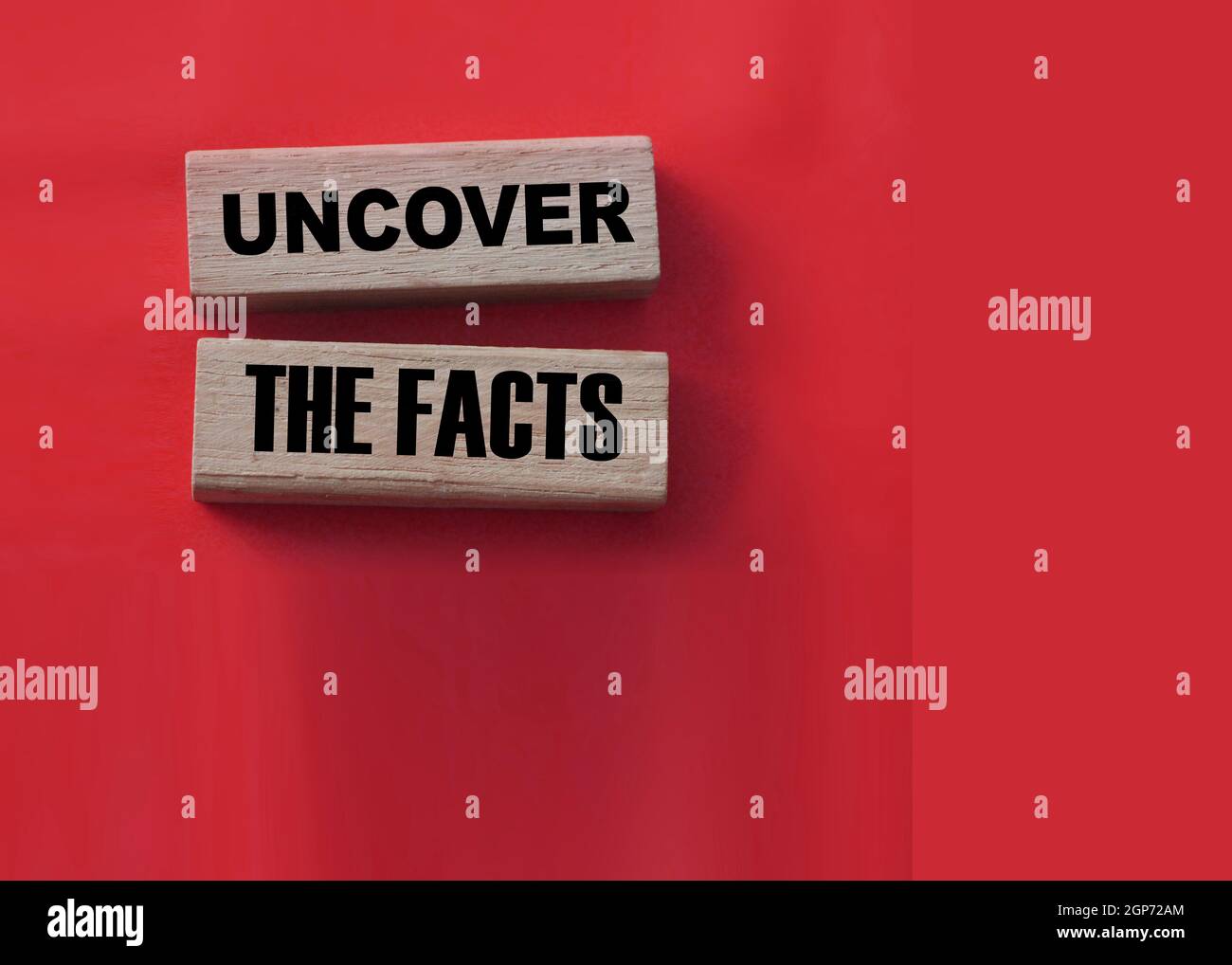 Uncover the facts word on wooden blocks on red background. Fake or real ...