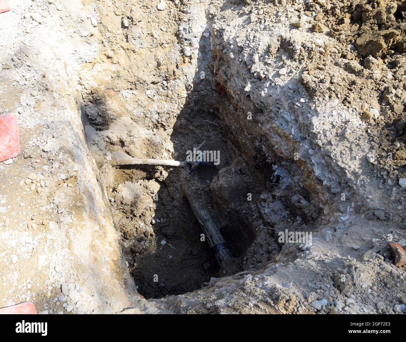 An excavated pit with a damaged pipeline. Repair of communications ...