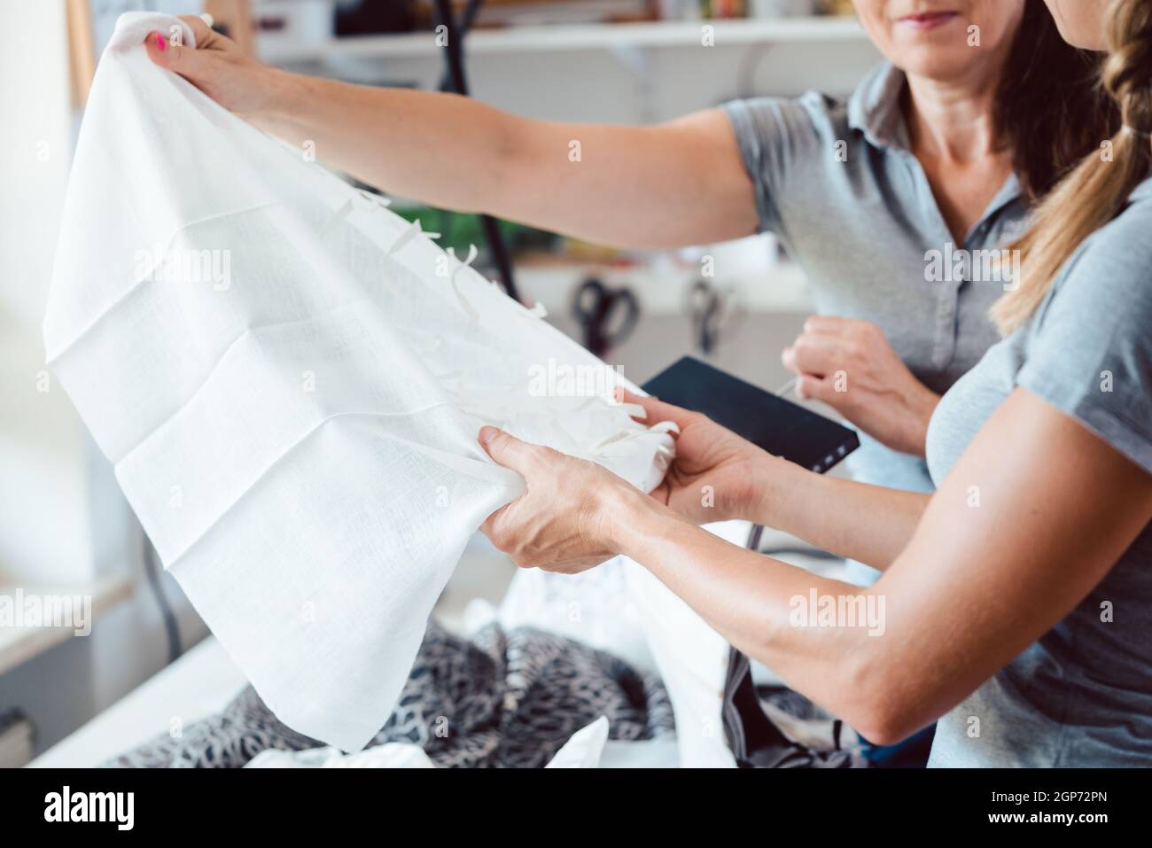 Designers inspecting sample fabric with their hands in a studio Stock ...