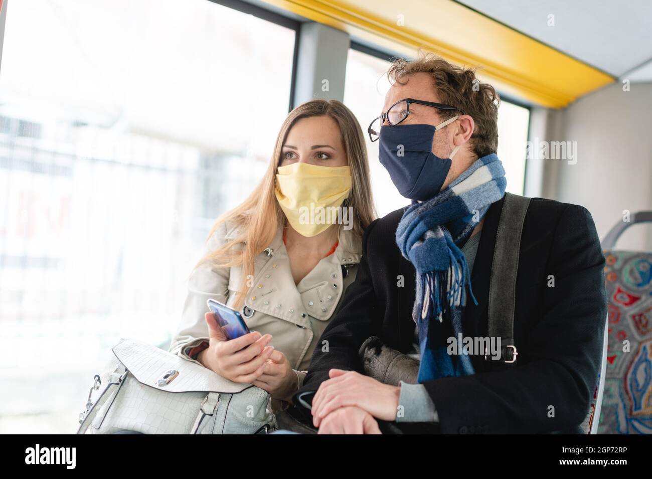 Couple in public transport bus wearing masks, man and woman Stock Photo - Alamy