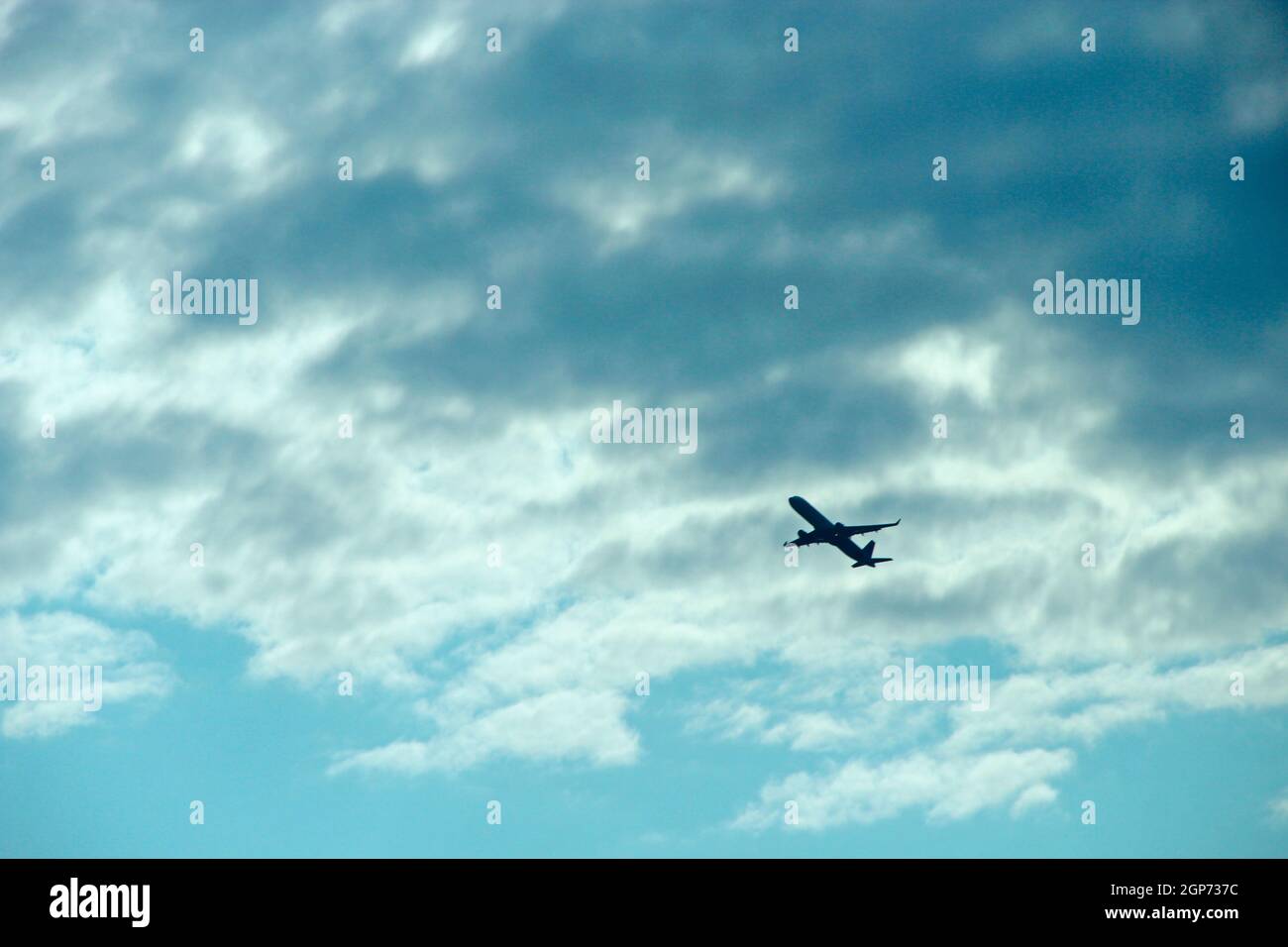 Plane flying high in sky. View to air liner flying in blue sky ...