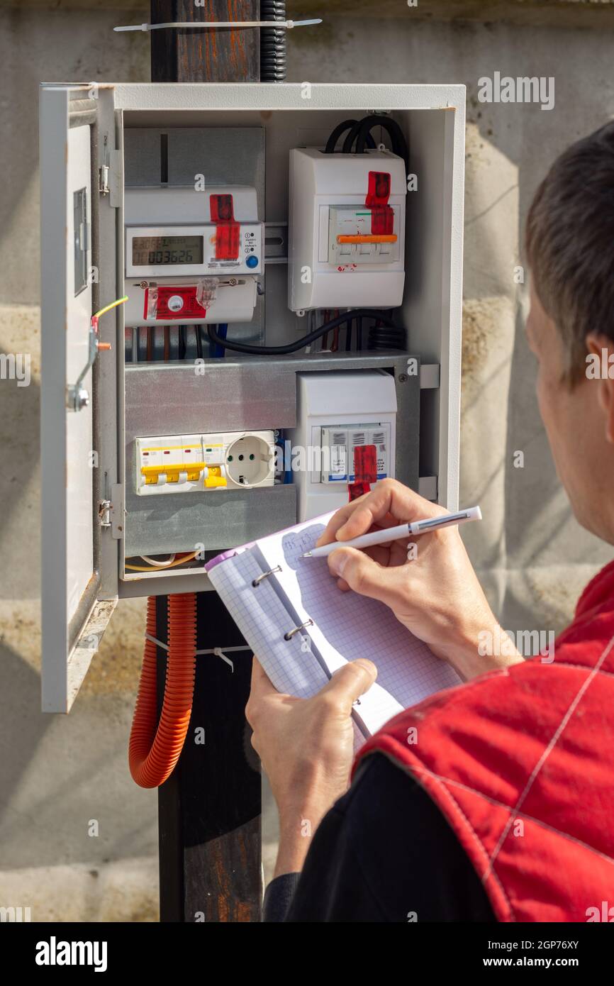 The gardener takes control readings of electricity meters Stock Photo ...
