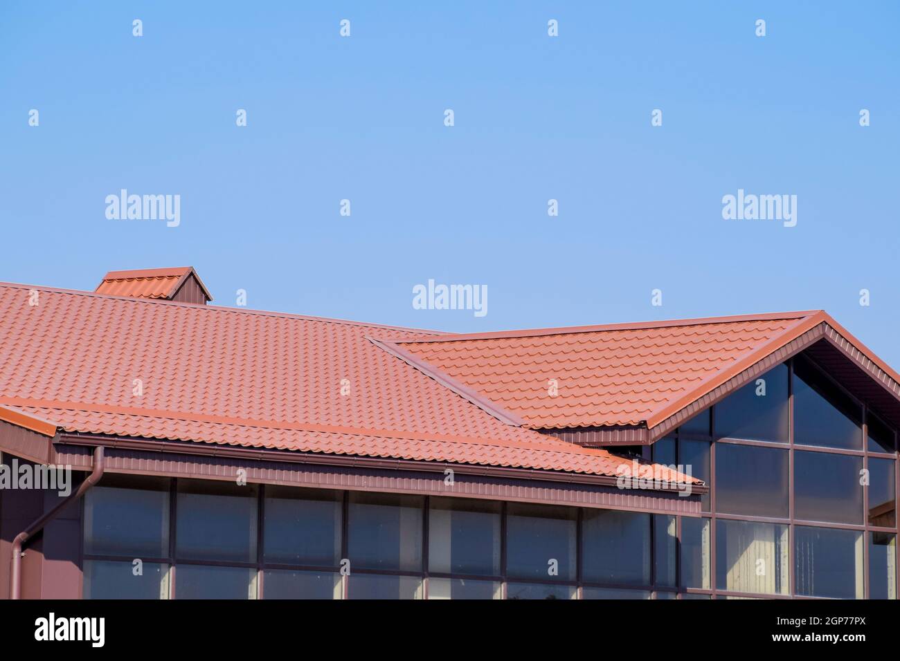 A building with a red-brown roof. Modern materials of finish and ...