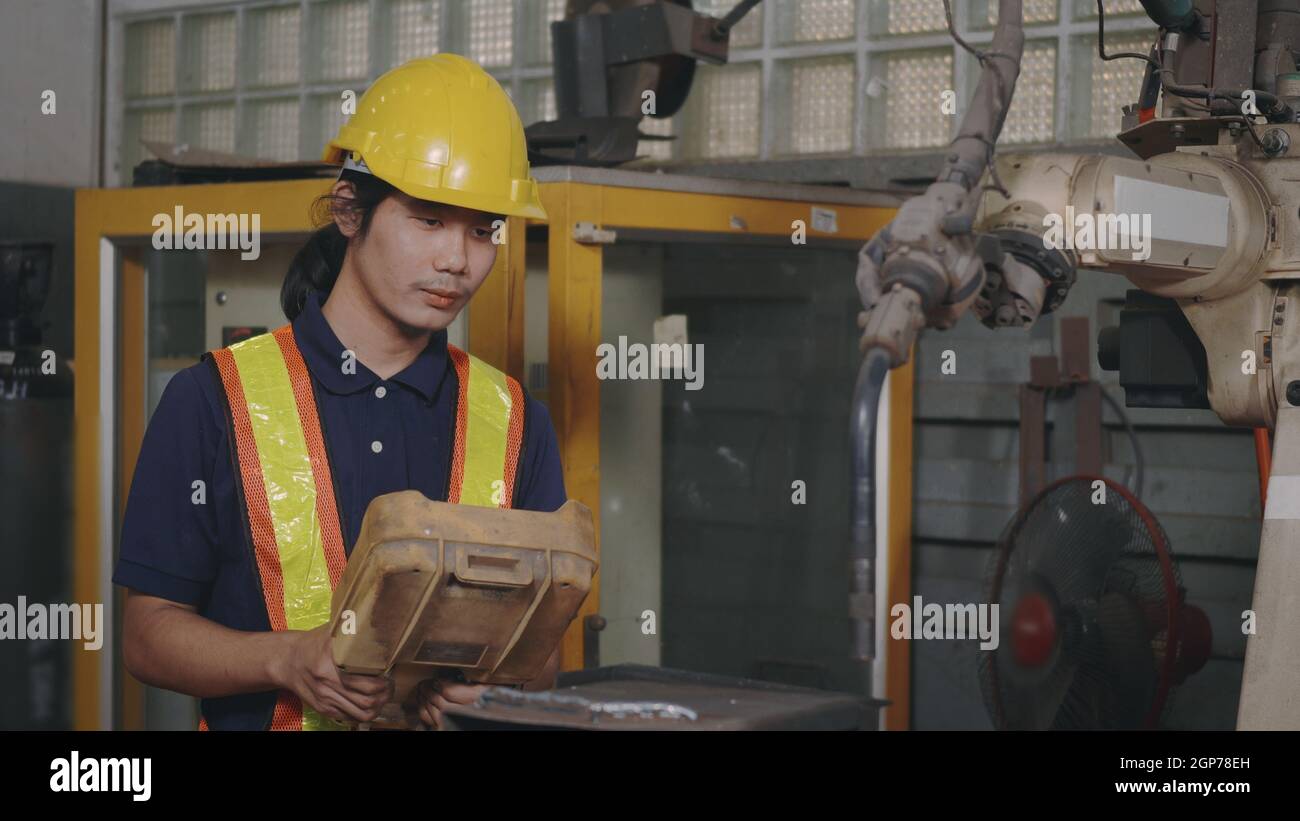 Asian engineering man check and control welding robotics automatic arms ...