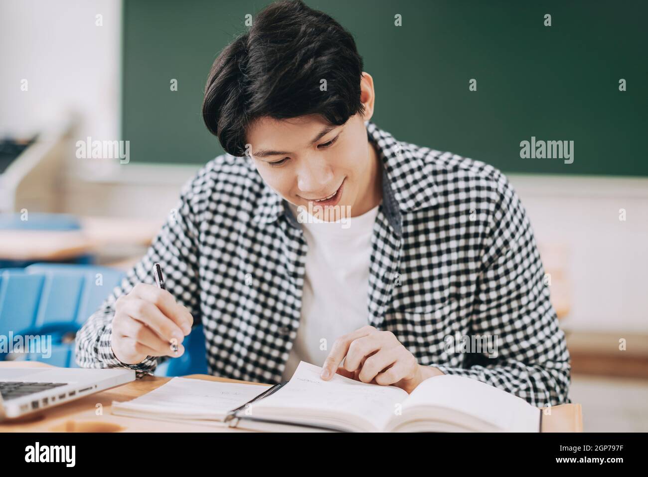 Young cheerful asian student studying in classroom Stock Photo - Alamy