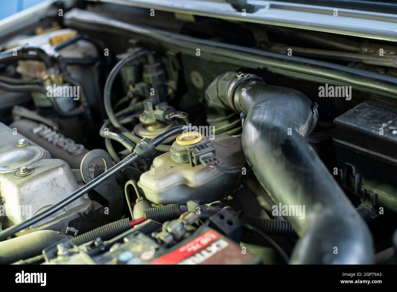 Detail of a used engine with mechanical parts on view inside a car ...