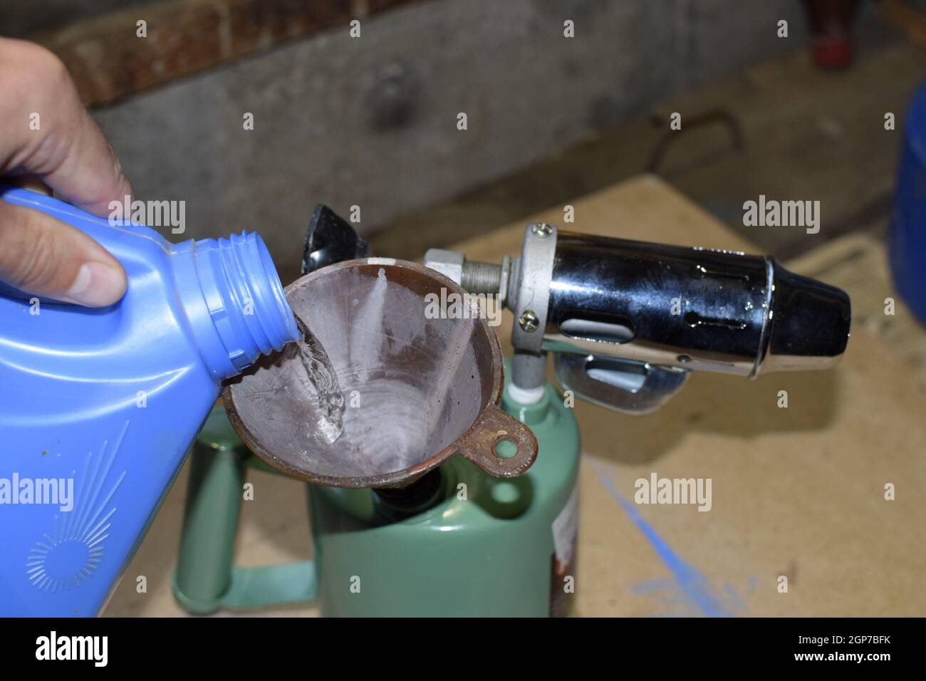 Pouring gasoline blowtorch through the funnel Stock Photo - Alamy
