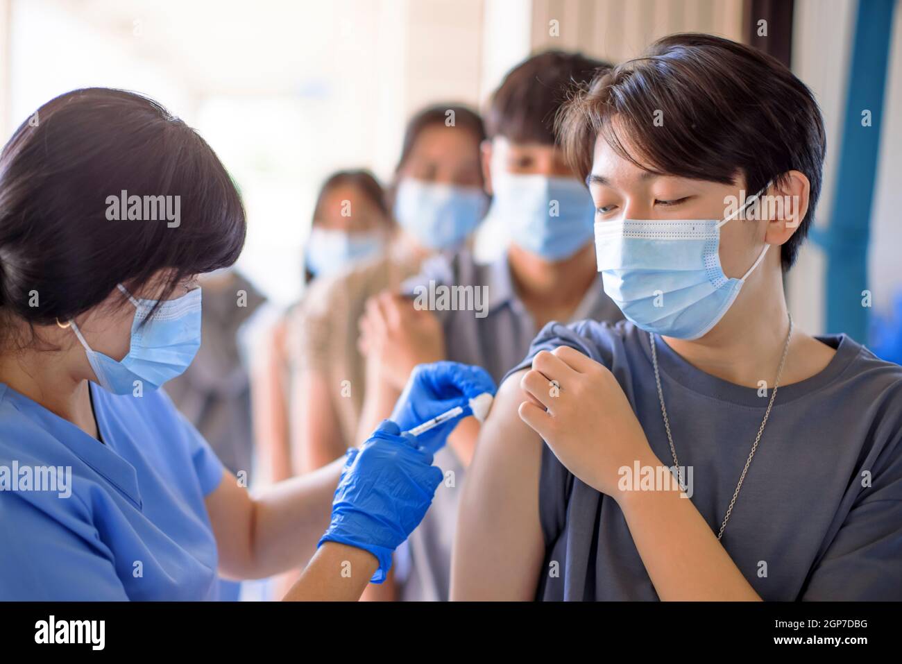 Doctor injecting vaccine for students in high school Stock Photo - Alamy