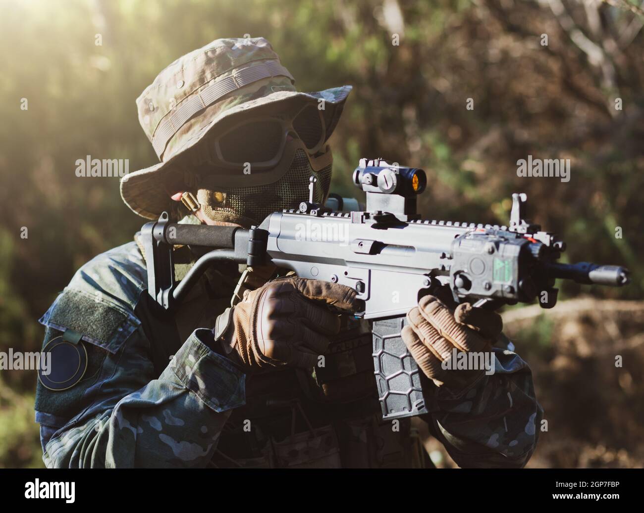 Airsoft military game player in camouflage uniform with armed assault ...