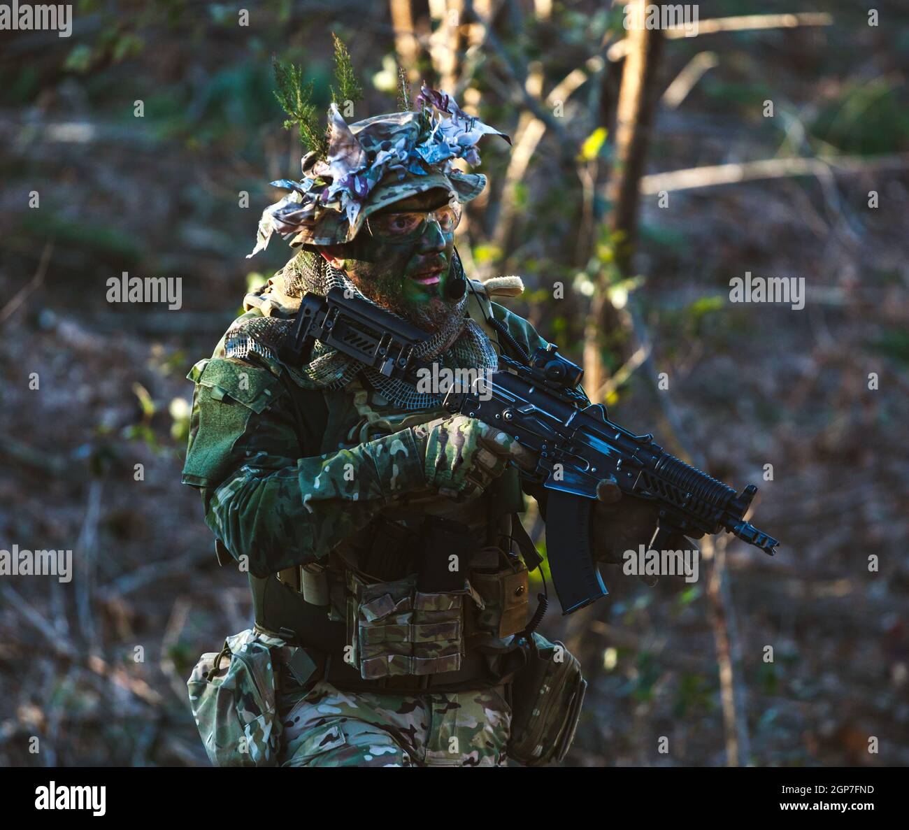 Airsoft military game player in camouflage uniform with armed assault ...