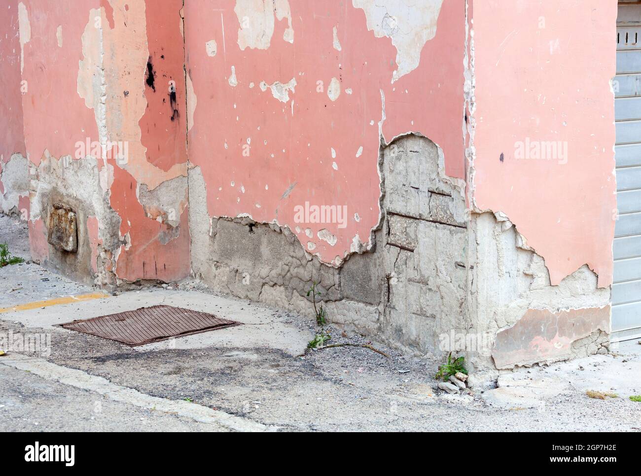 Wall of an old building with ruined plaster and cracks in the concrete ...