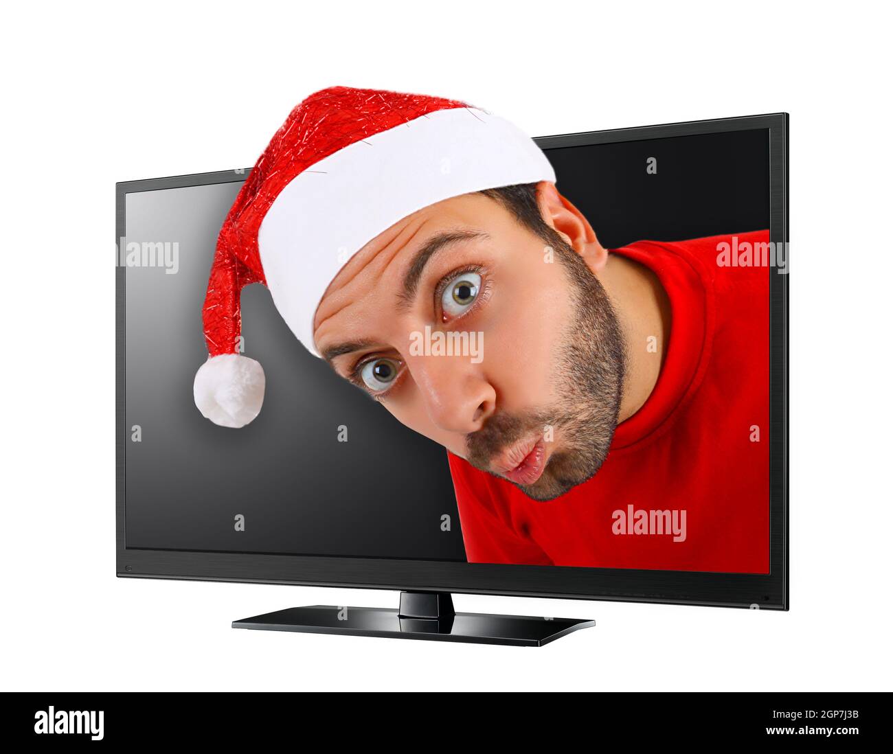 Young man with hat of Santa Claus comes out from the TV on white ...