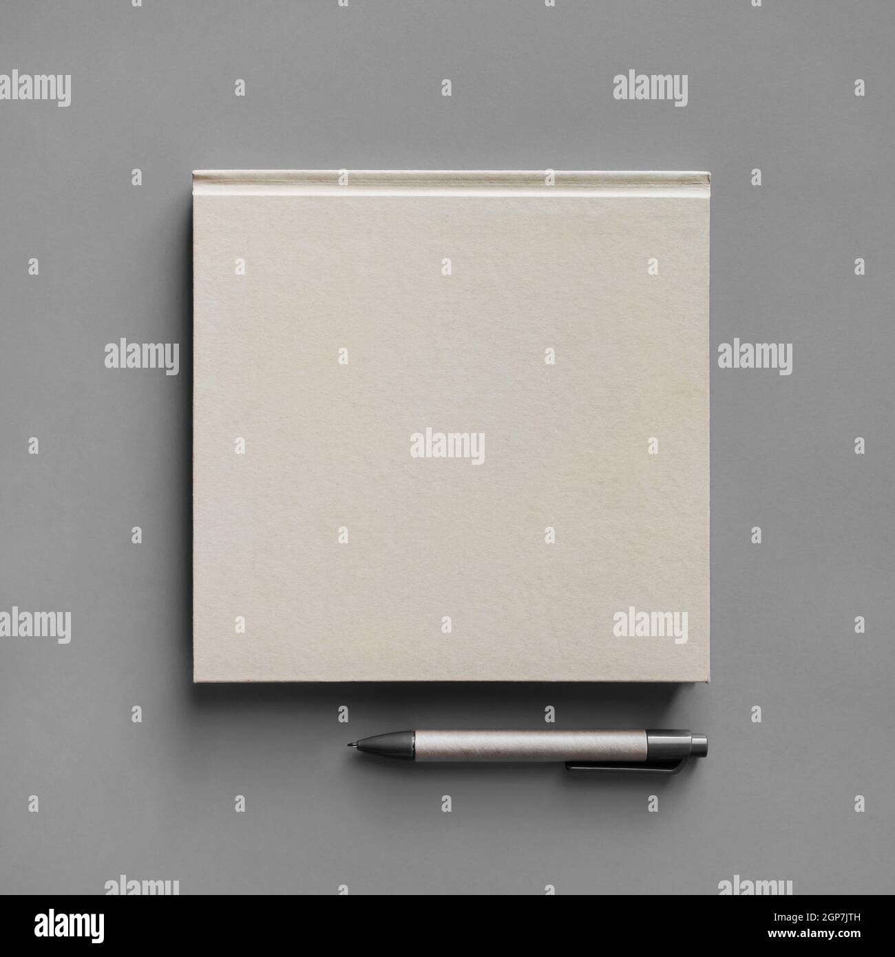 Blank square booklet and pencil on gray background. Template for ...
