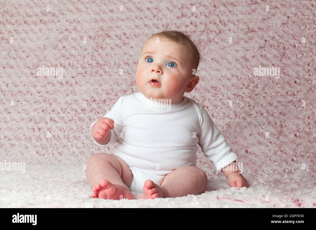 Sitting newborn baby girl with white bodysuit on blanket Stock Photo ...