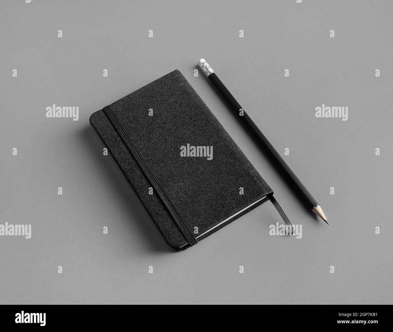 Blank black notepad and pencil on gray paper background. Template for ...
