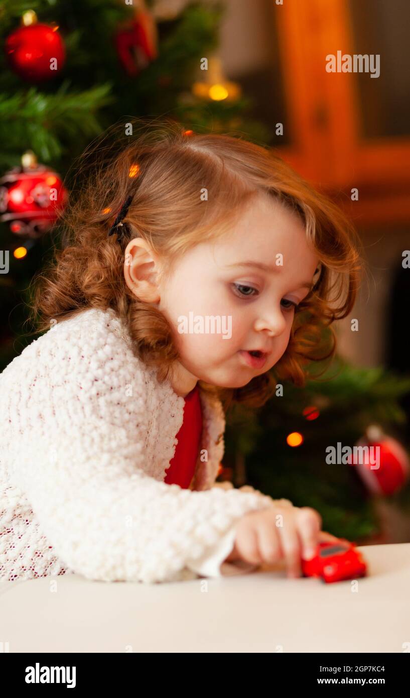 Beautiful little child plays with little red toy car Stock Photo - Alamy