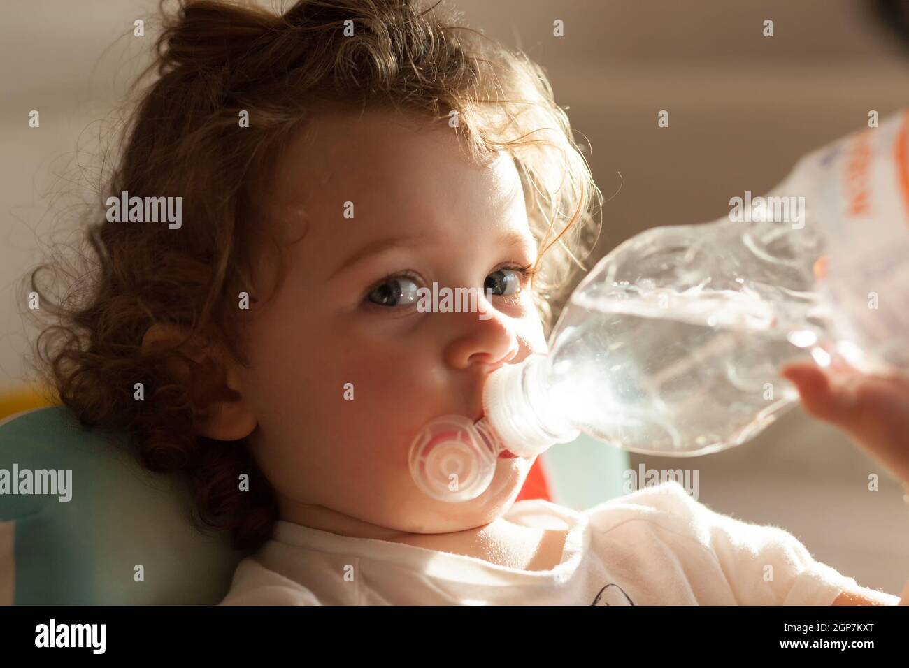 Little baby girl drinking fresh water from plastic bottle Stock Photo - Alamy