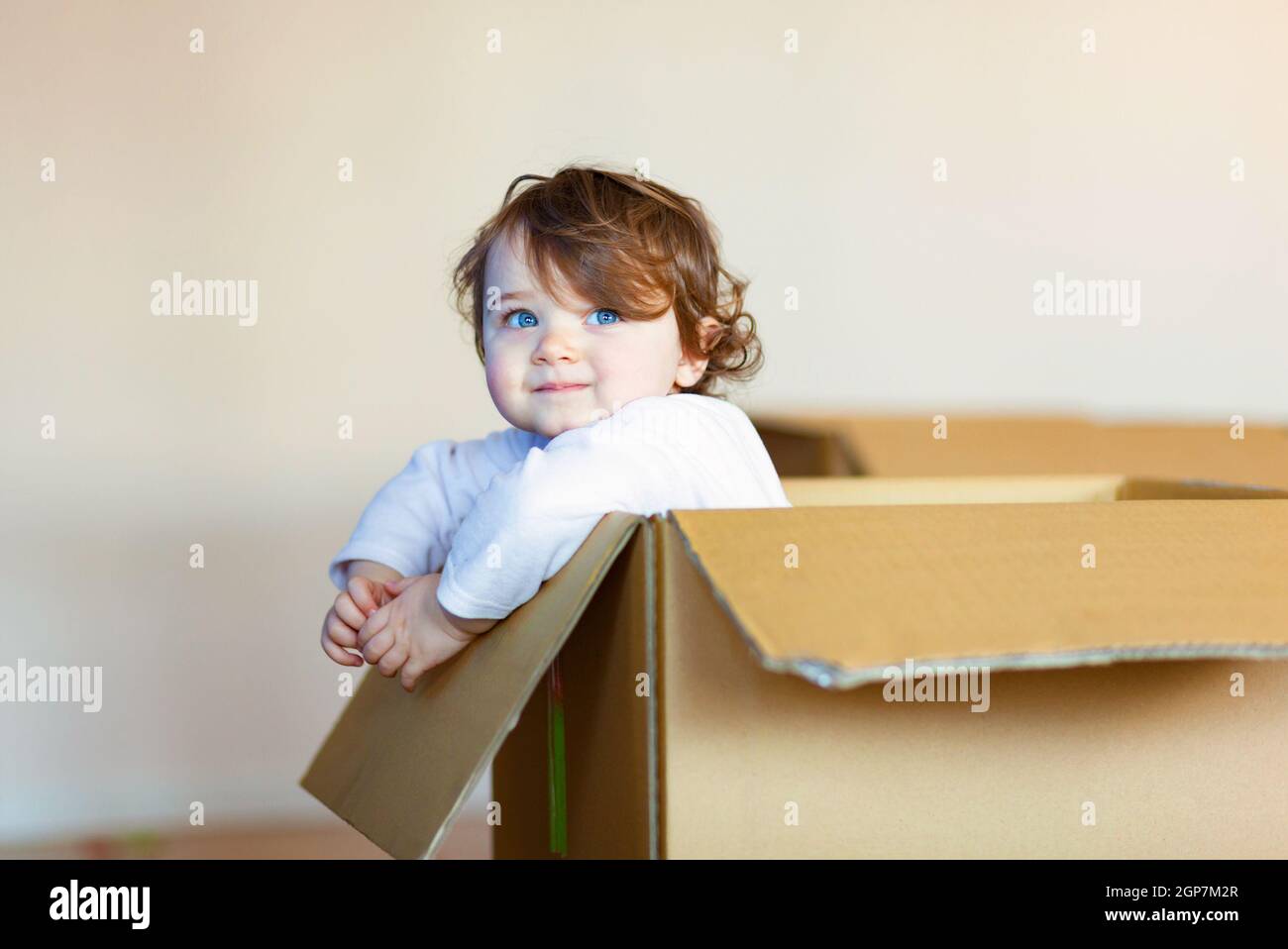 Cute smiling toddler baby girl sitting inside brown cardboard box Stock ...