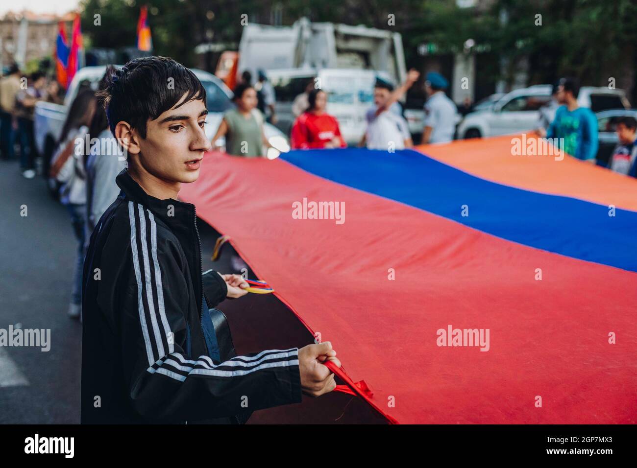 Yerevan, Armenia. 26th Sep, 2021. A young man carries an Armenian flag ...