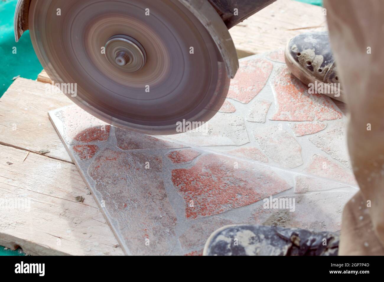 A man cutting a floor tiles with a grinder Stock Photo - Alamy